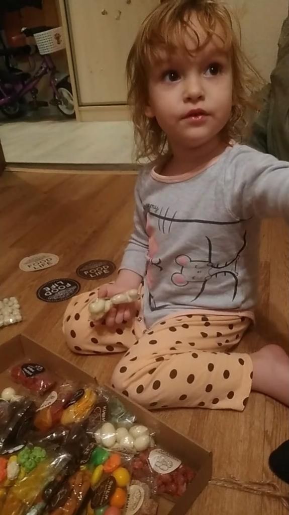 Арина делит сладости между родителями и машинками Мокас