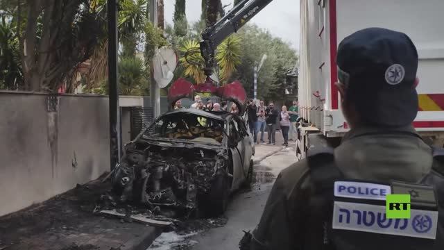 مركبات مدمرة جراء حريق ناجم عن سقوط شظايا صاروخية في وسط إسرائيل