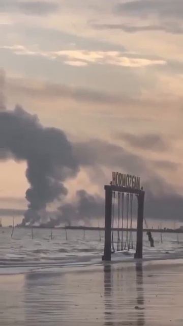 Иранская девочка качается на качелях на фоне горящей базы