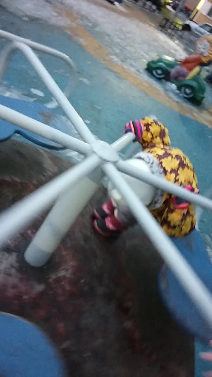 Арина катается на карусели своим определённым способом.