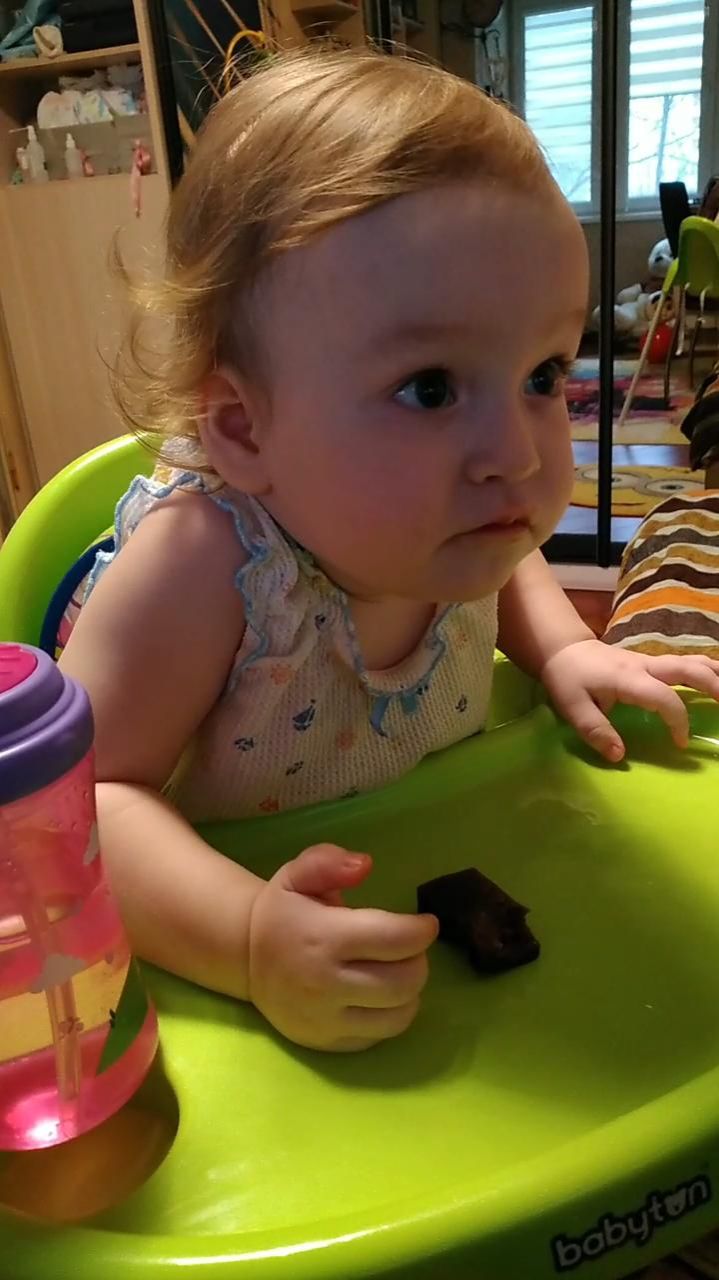 Арина смотрит мультики за своим любимым зелёным столом.