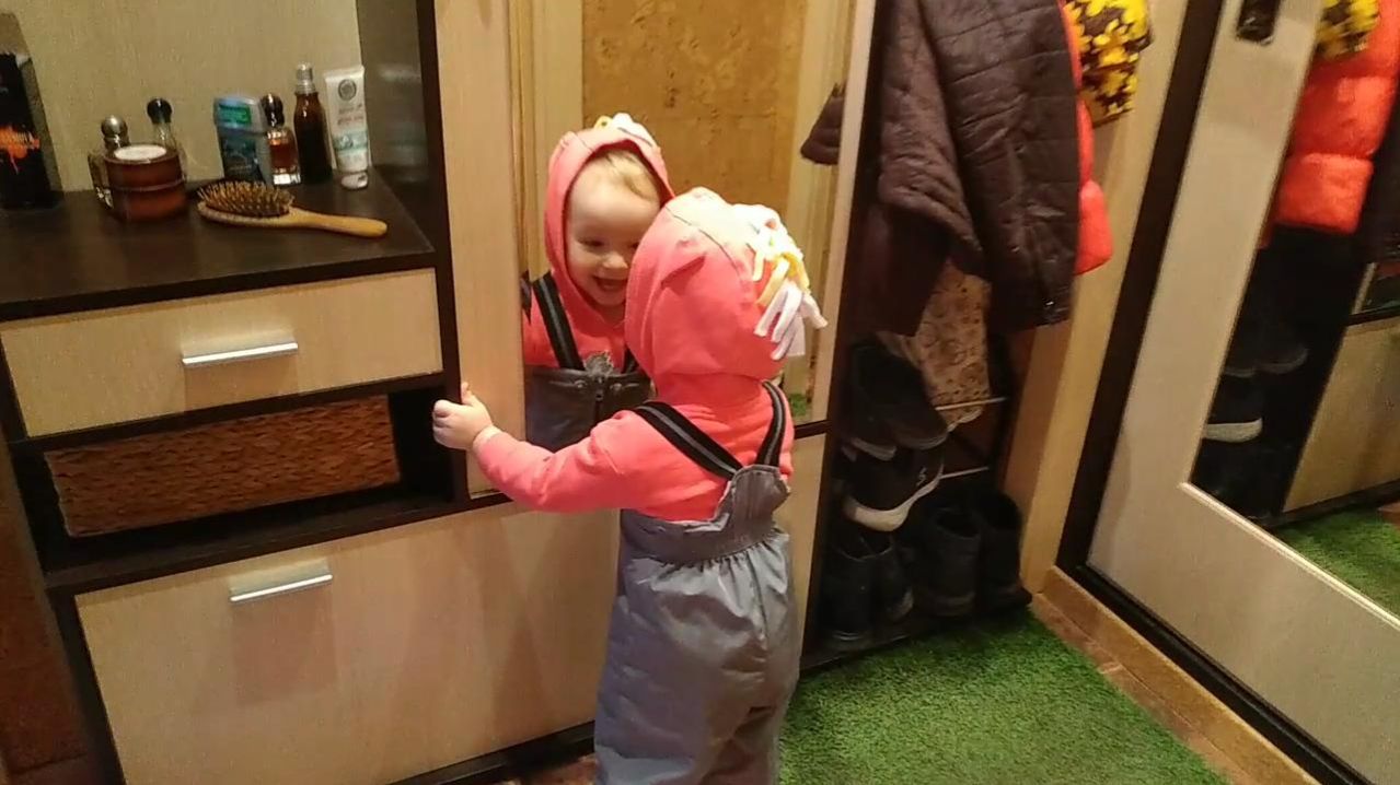 Арина играет с зеркалом. Изучает девочку, которая находится за ним и радуется