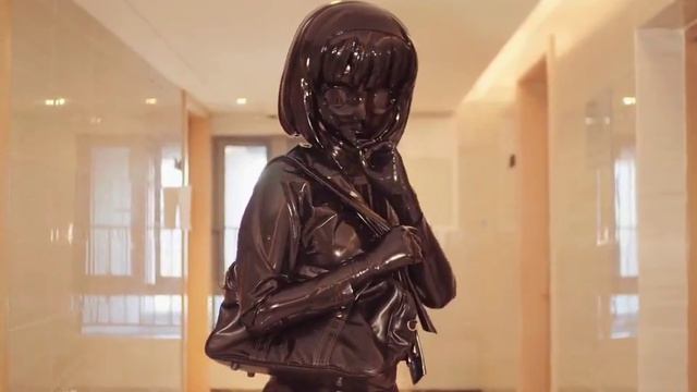 Кигуруми-кукла в латексной школьной форме идет по коридору.