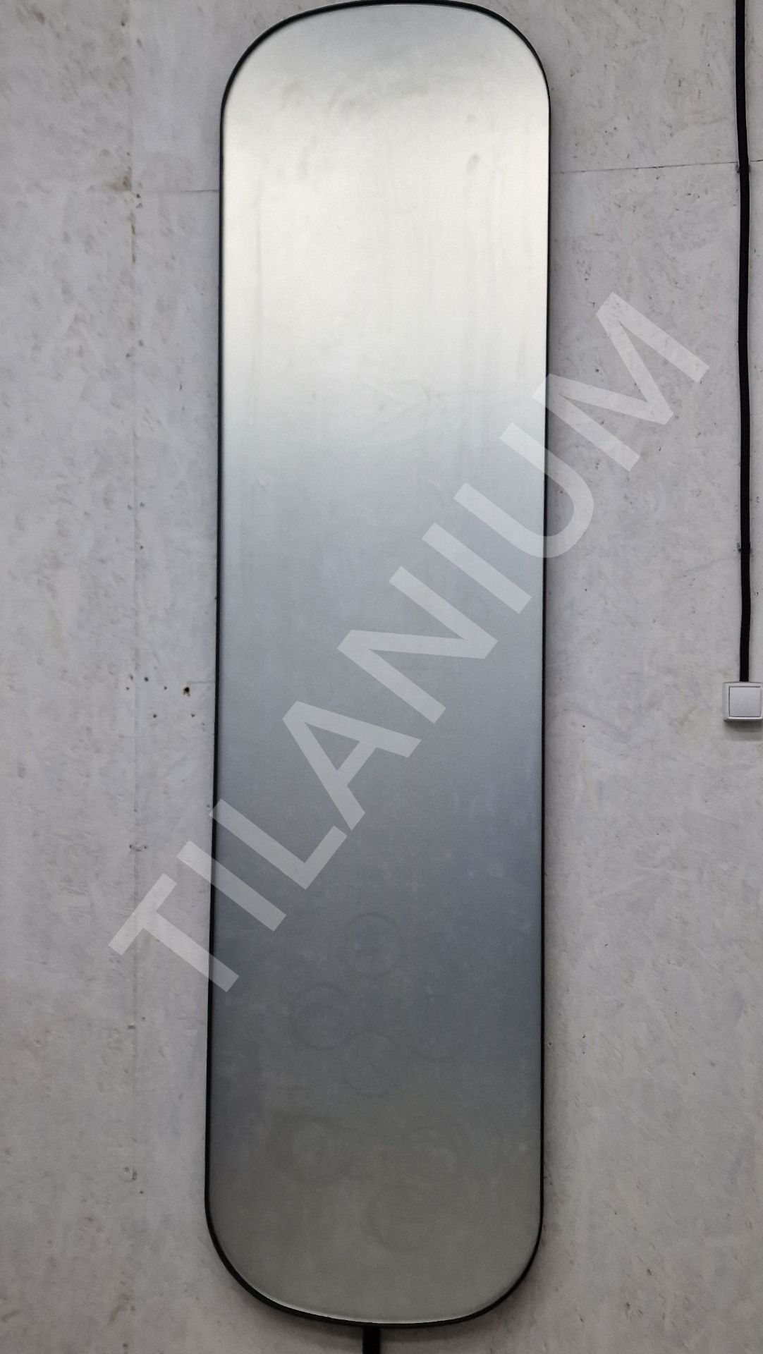 Зеркало в черной тонкой металлической раме на штанге