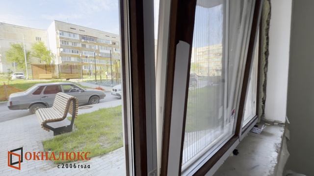 На окне РЕХАУ Интелио со внутренней ламинацией золотой дуб установили белую москитную сетку плиссе