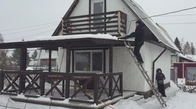 Зимняя дача. Скидываю снег с крыши террасы.