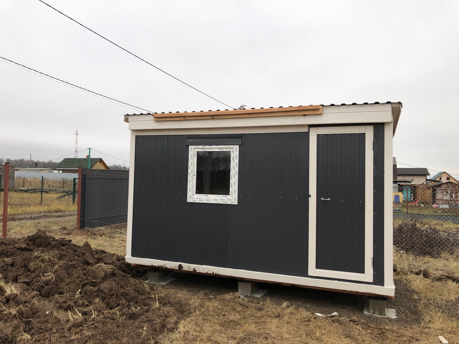 Поставили бытовку - сарай. Площадка под бытовку.