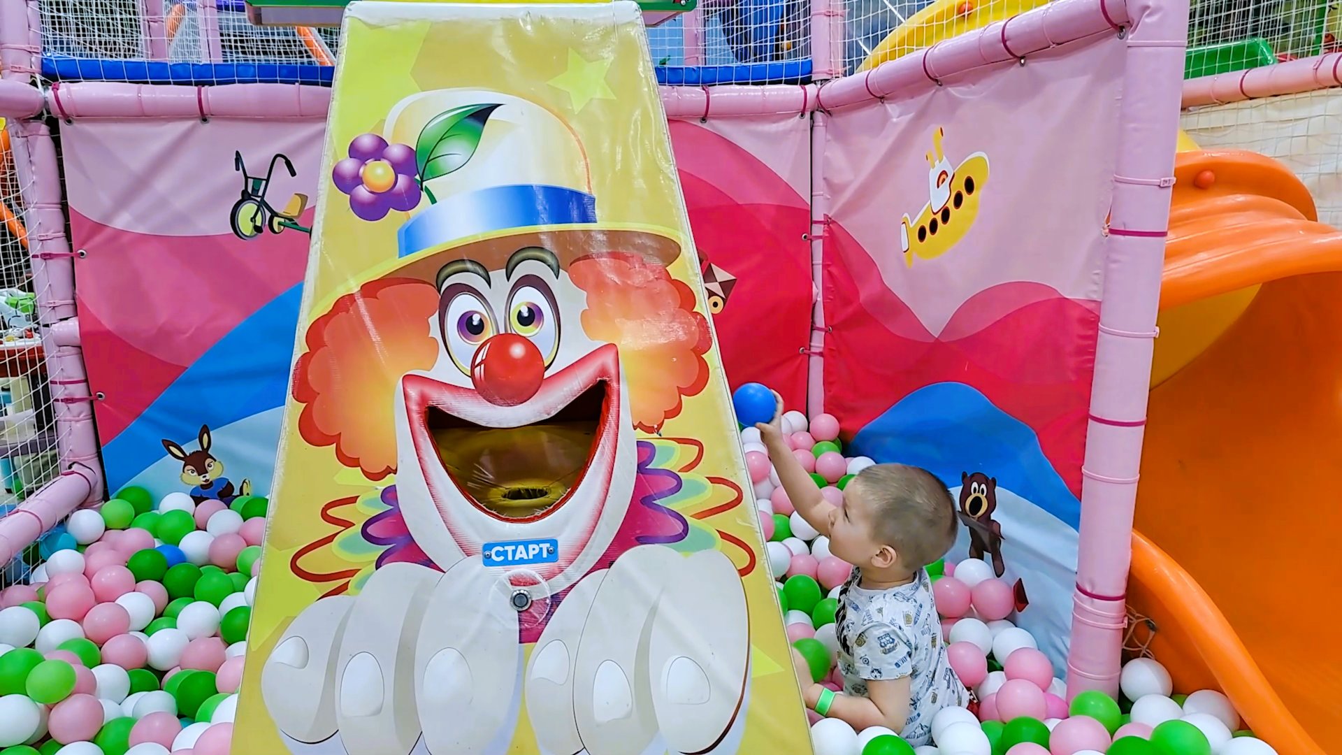 Детская площадка ребенок играет с шариками катается с горки