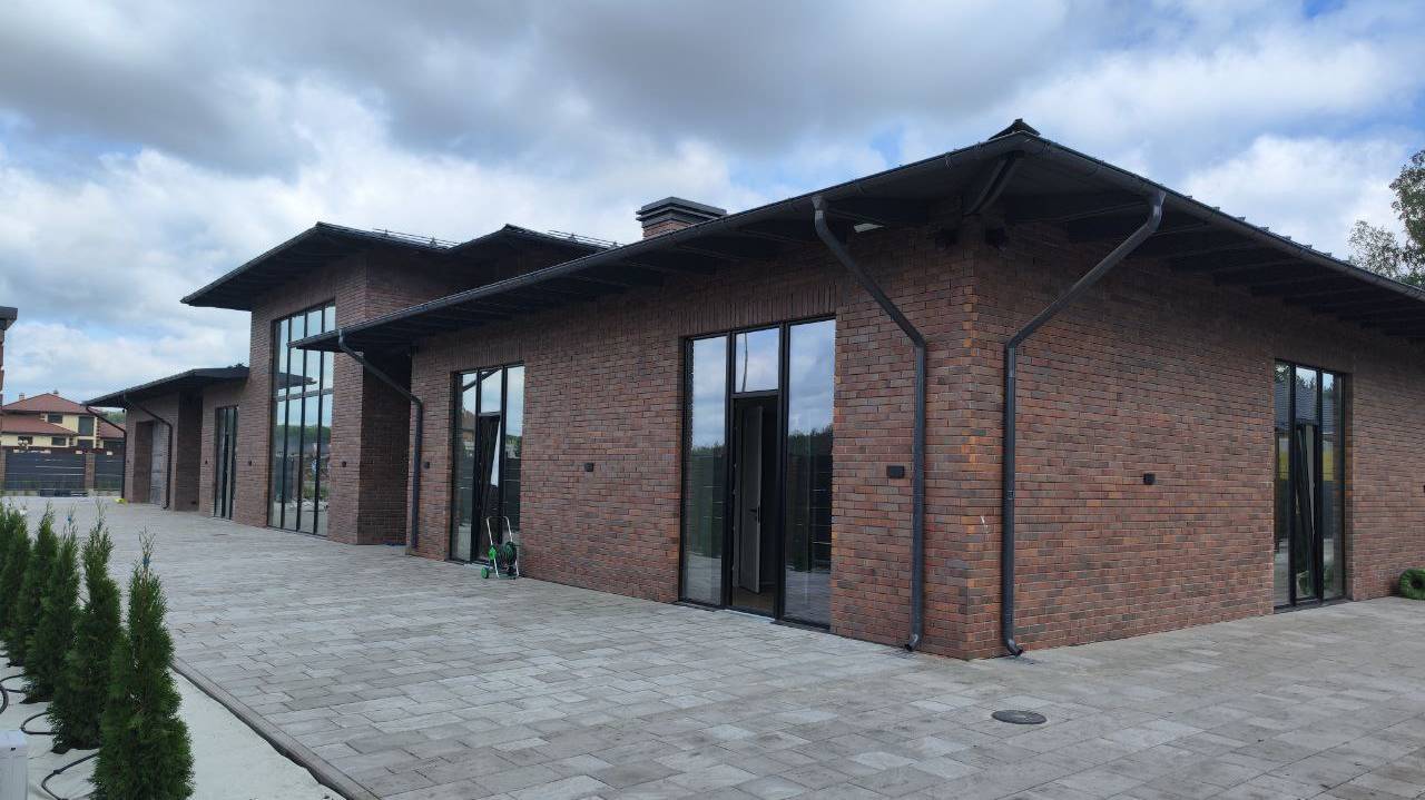 Обзор одноэтажного дома 540м2 с фальцевой кровлей, кирпичным фасадом и панорамными окнами.