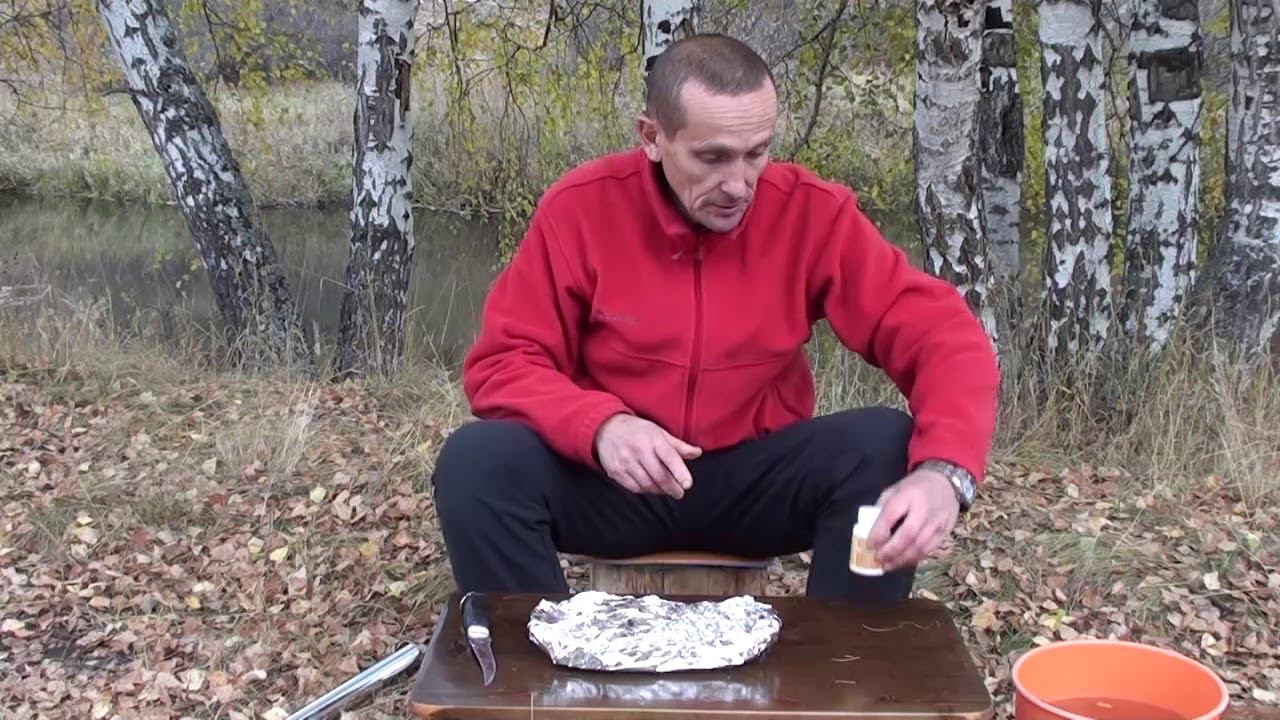 Рыба на углях в фольге на природе.