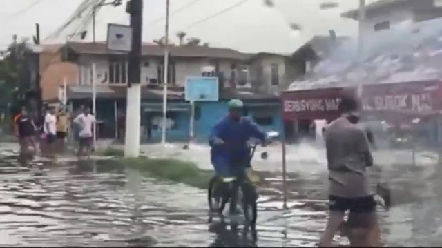 Филиппинцы устраивают заплыв в лужах, появившихся после дождя.