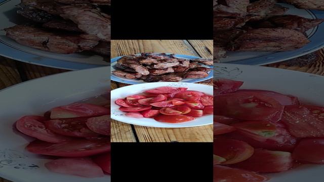 Вечерний ужин , тарелка шашлыка и тарелка помидоров .