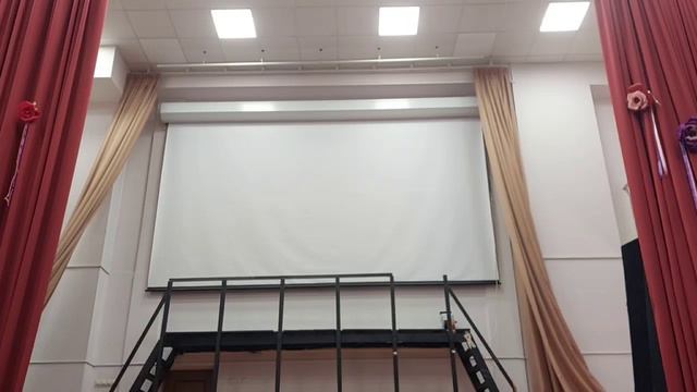Экран с электроприводом шириной 6 метров для актового зала школы
