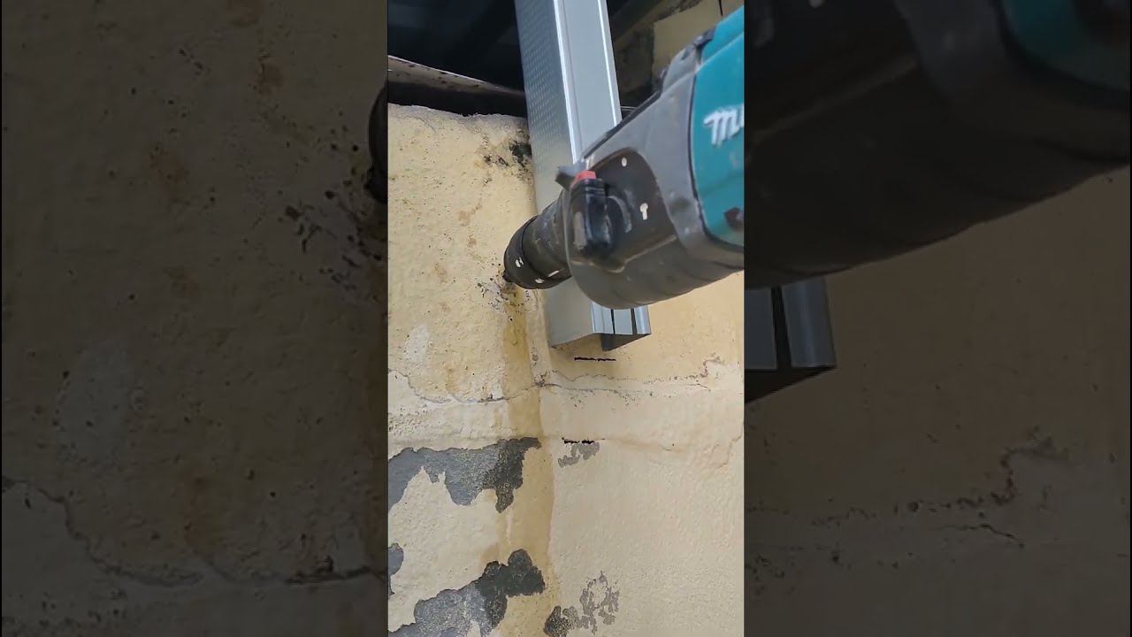 Работа перфоратора. Сверление отверстия в бетонной плите, перфоратором. Ручеёк выходит из плиты.