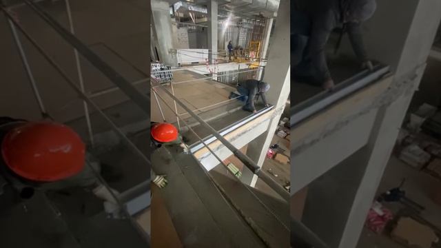 Процесс установки стеклянных перил в торговом центре